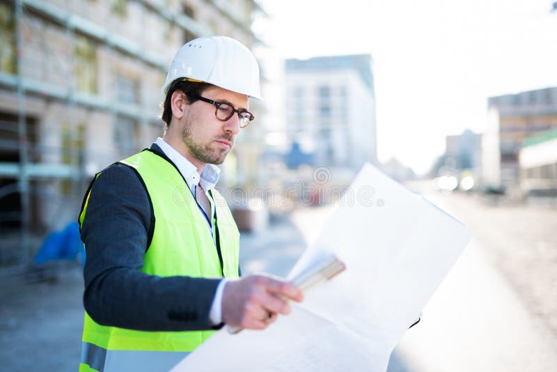 An Architect / Civil Engineer at Work on a Construction Site, Holding ...