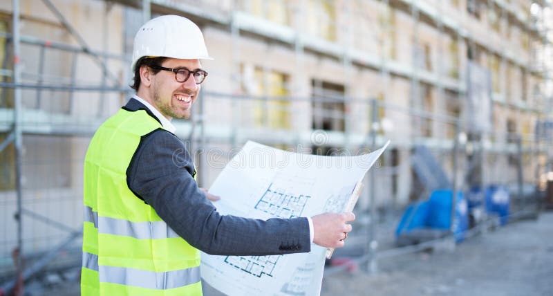 An Architect / Civil Engineer at Work on a Construction Site, Holding ...