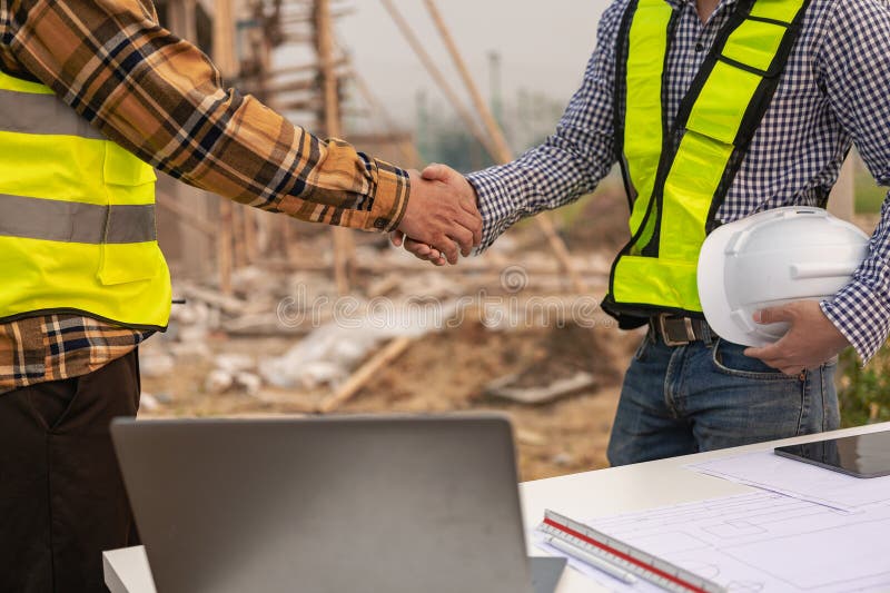 Architect and Construction Engineer Holding Hands while Working for ...