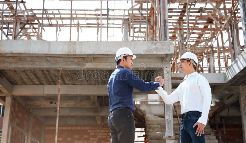 Architect and Construction Worker Engineers Shaking Hands while Working ...