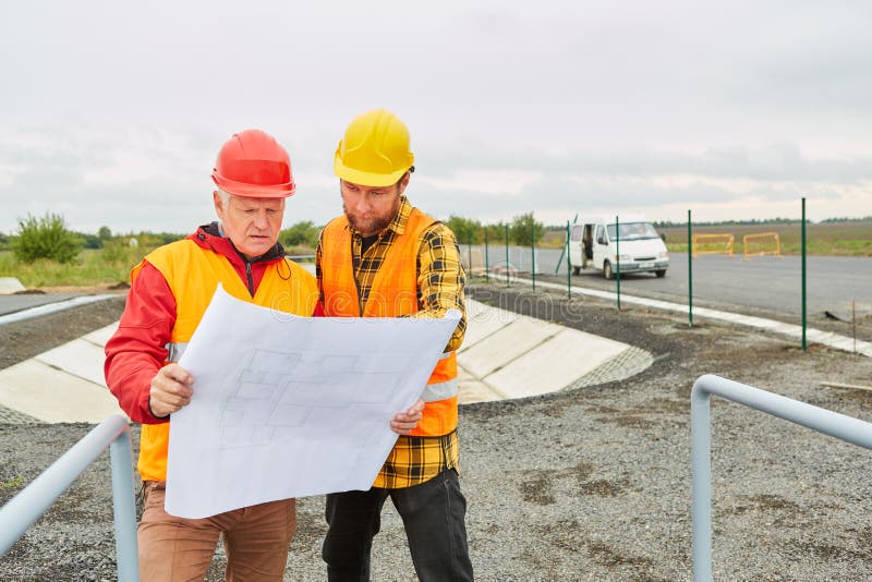 Architect and Construction Worker Look at Architectural Drawing Stock ...