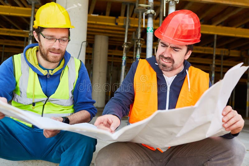 Architect and Construction Worker Look at Construction Drawing Stock ...