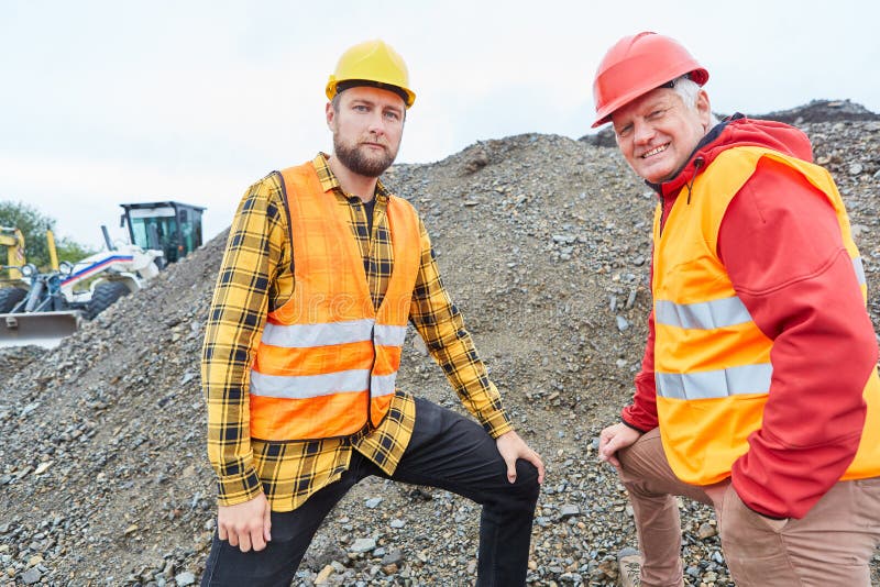 Architect and Construction Worker Stand in Front of a Mound of Earth ...