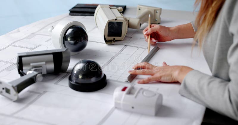 Architect Designing CCTV Security Alarm System with Blueprints Stock ...