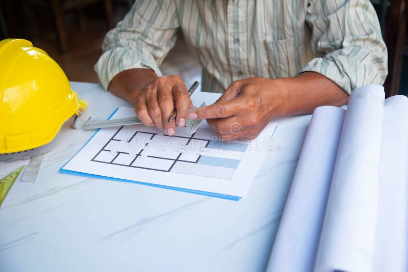 Architect Designing Project at Construction Site with Blueprint Stock ...