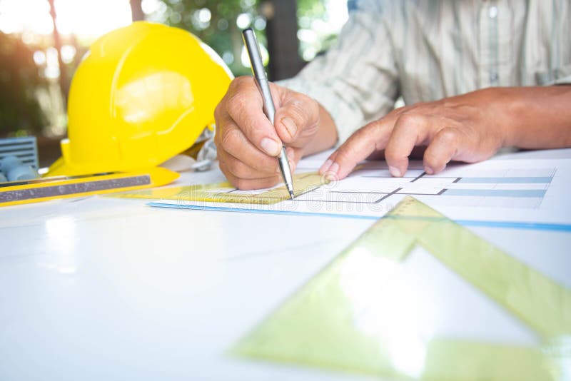 Architect Designing Project at Construction Site with Blueprint Stock ...