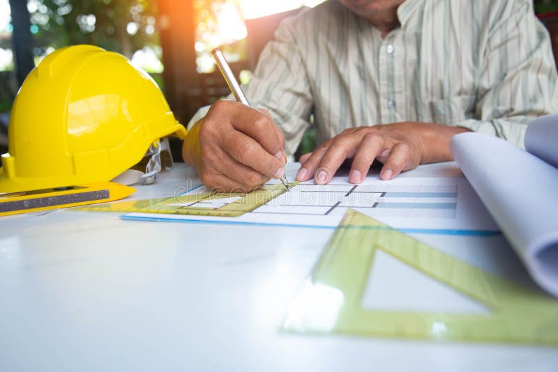 Architect Designing Project at Construction Site with Blueprint Stock ...