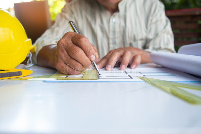 Architect Designing Project at Construction Site with Blueprint Stock ...