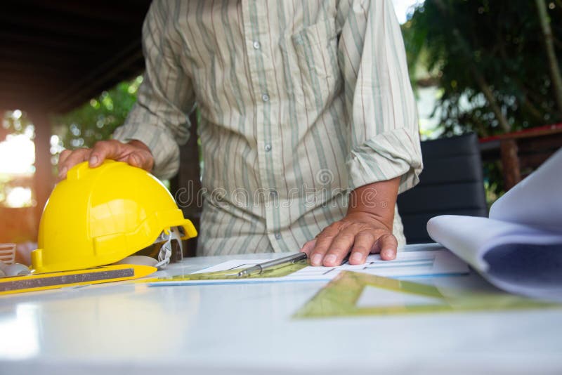 Architect Designing Project at Construction Site with Blueprint Stock ...