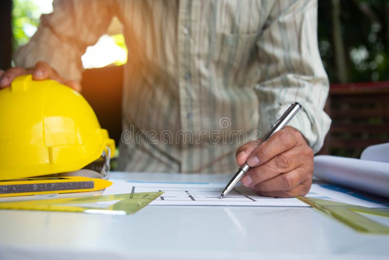 Architect Designing Project at Construction Site with Blueprint Stock ...