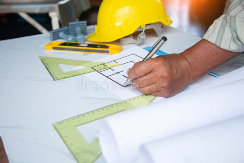 Architect Designing Project at Construction Site with Blueprint Stock ...