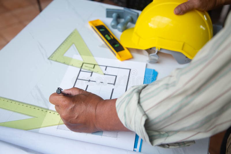 Architect Designing Project at Construction Site with Blueprint Stock ...