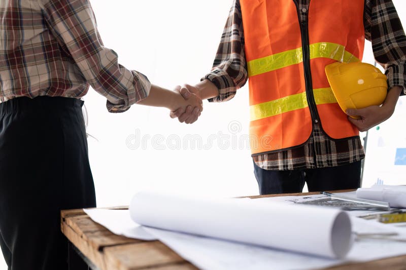 Architect and Engineer Construction Workers Shaking Hands while Working ...