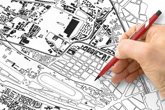 Architect or Engineer Drawing Over an Imaginary City Map of Territory ...