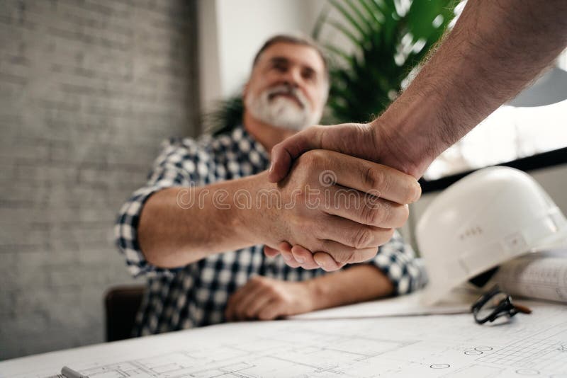 Architect and Engineer Workers Shaking Hands while Working for Teamwork ...