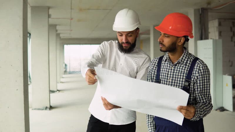 Architect is Explaining To Indian Builder the Plan of Construction. the ...