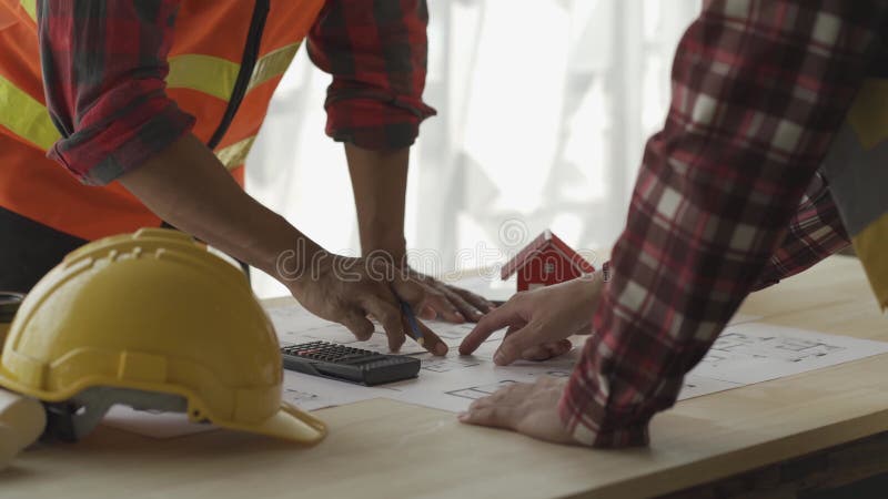Architect and Foreman Looking at Blueprints and Planning Building ...