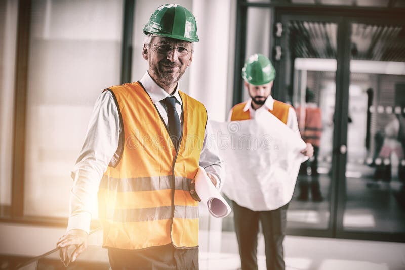 Architect in Hard Hat Standing with Blueprint in Office Corridor Stock ...