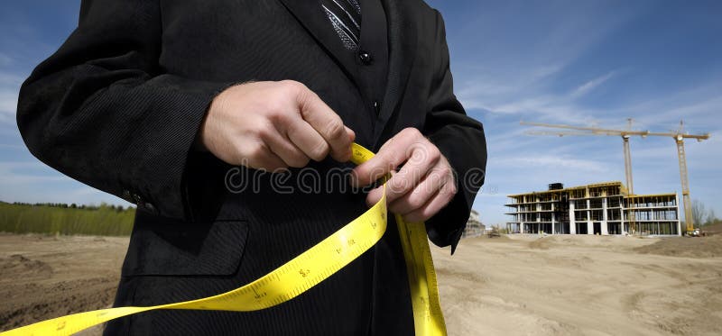 Architect Holding Measuring Tape at Construction Site with Crane Stock ...