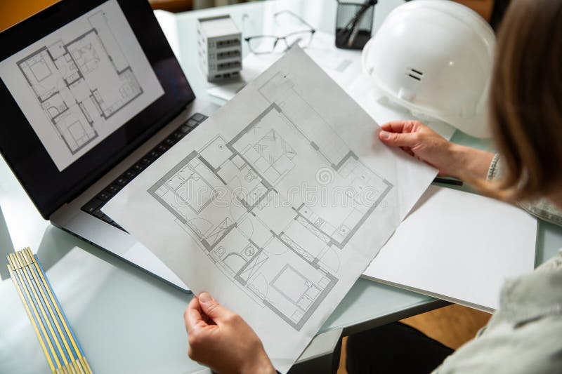 Architect Holding and Working on a Technichal Blueprint Project of New ...