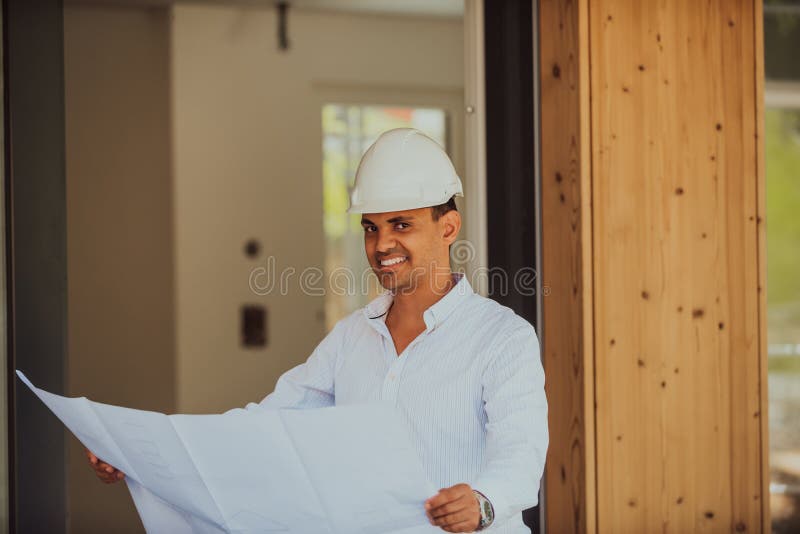 A Architect Looking at Plan and Thinking about Working on Big Project. Building in Construction ...