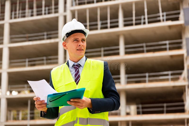Architect in Protective Helmet and Jacket with Folder of Documents on ...