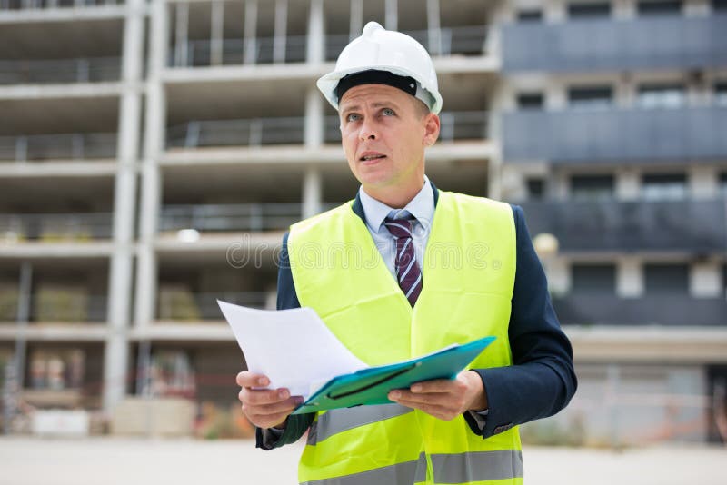 Architect in Protective Helmet and Jacket with Folder of Documents on ...
