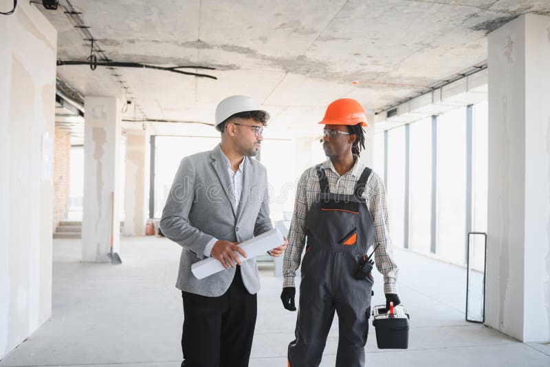 Architect Showing Blueprint To Builder Walking in Building Under ...