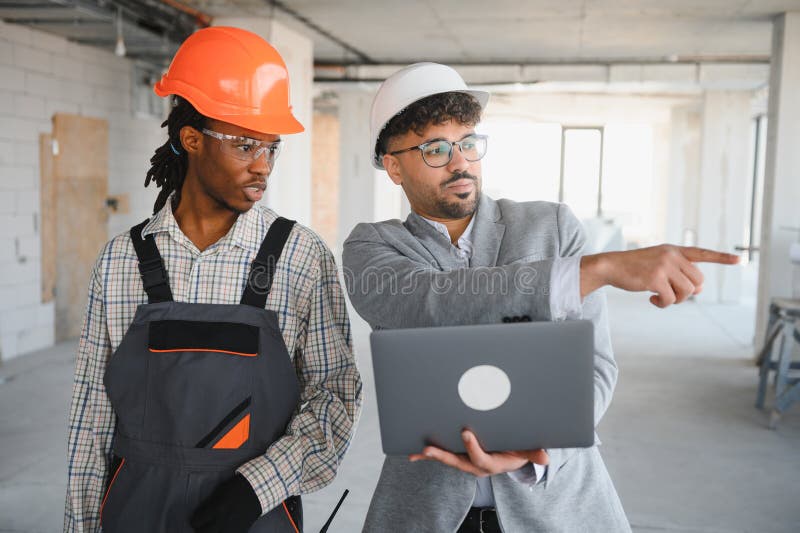 Architect Showing Instructions on Laptop To Builder during Construction ...