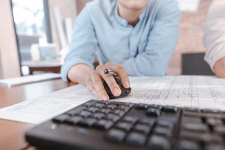 Architect Use Computer Mouse and Reading a Building and Drawing Outlay ...