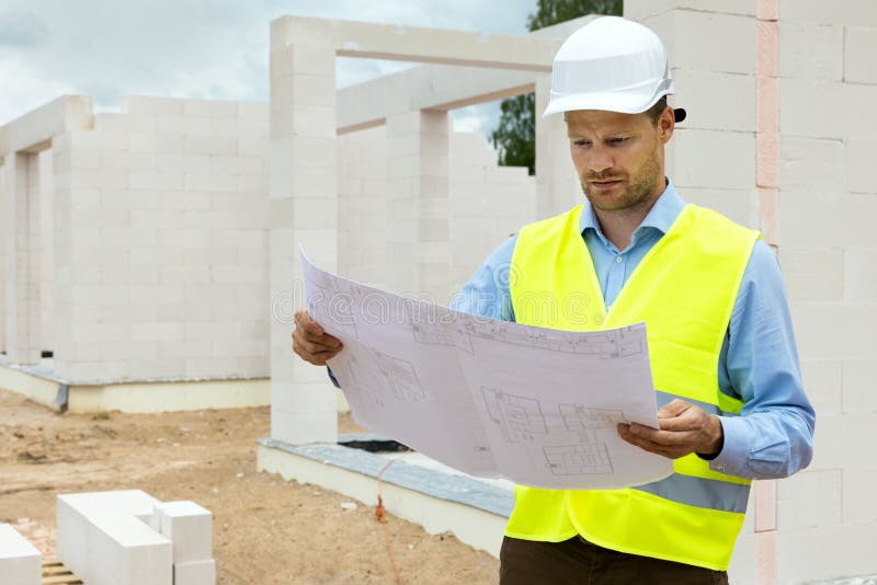 Architect Working with Blueprints at Construction Site. Project Control ...