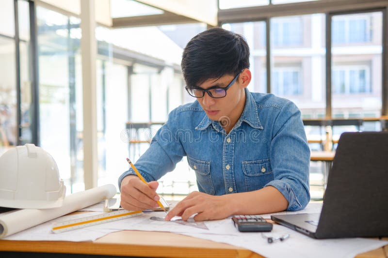 Architect Working on Blueprints at a Modern Workspace with Engineering ...
