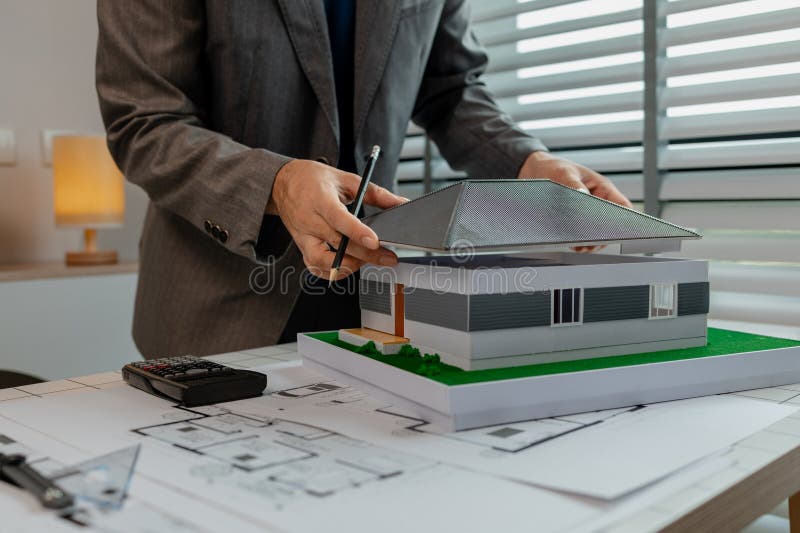 An Architect is Working in the Office, There are Blueprint and House ...