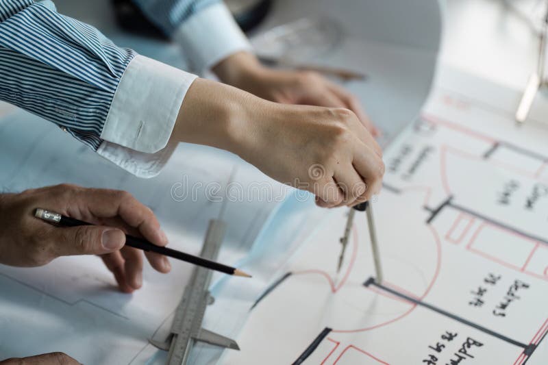 Architects Collaborating on Blueprint Design with Precision Tools in ...