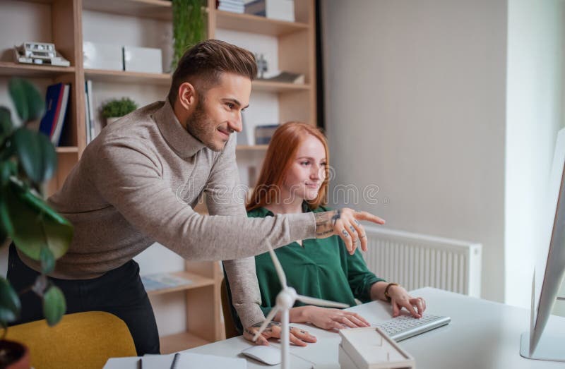 Architects with Computer Sitting at the Desk Indoors in Office, Working ...