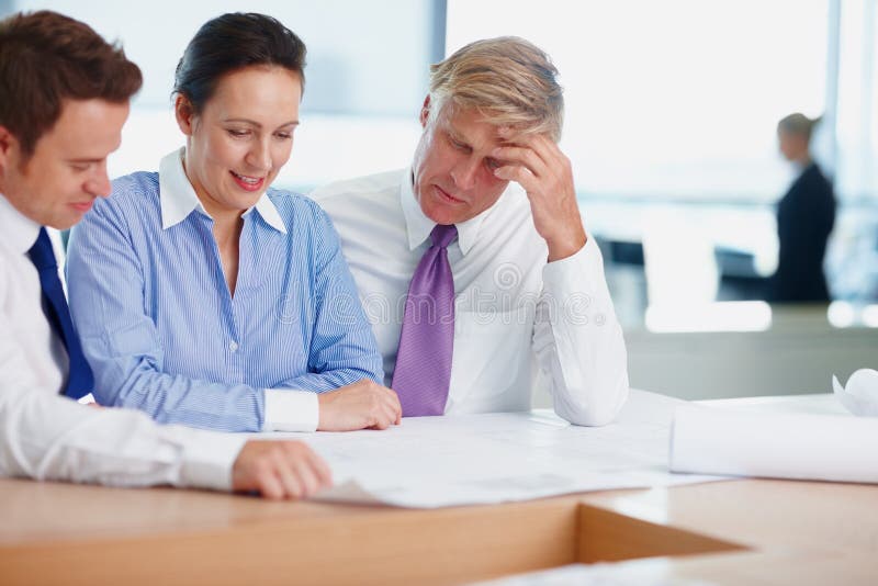 Architects Discussing on Blueprint. Three Architects Sitting at Table ...