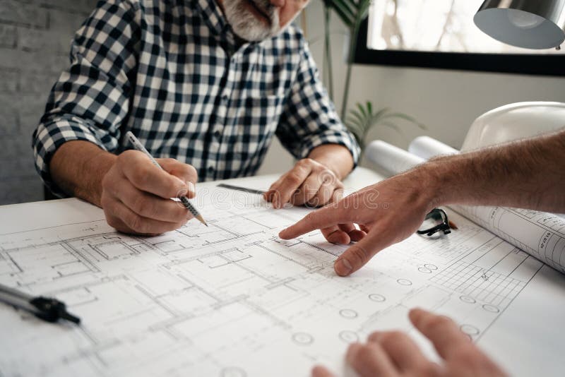 Architects Engineer Discussing at the Table with Blueprint - Closeup on ...