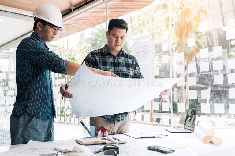 Architects or Engineering Working with Blueprints and Discussing ...