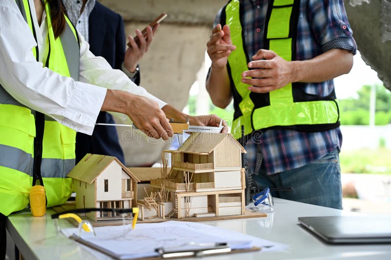 Architects Reviewing Blueprints and Notes on a Table at Construction ...