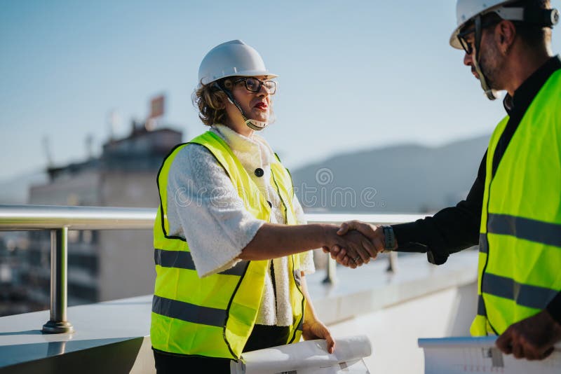 Architects Shaking Hands on Construction Site in High Visibility Vests ...