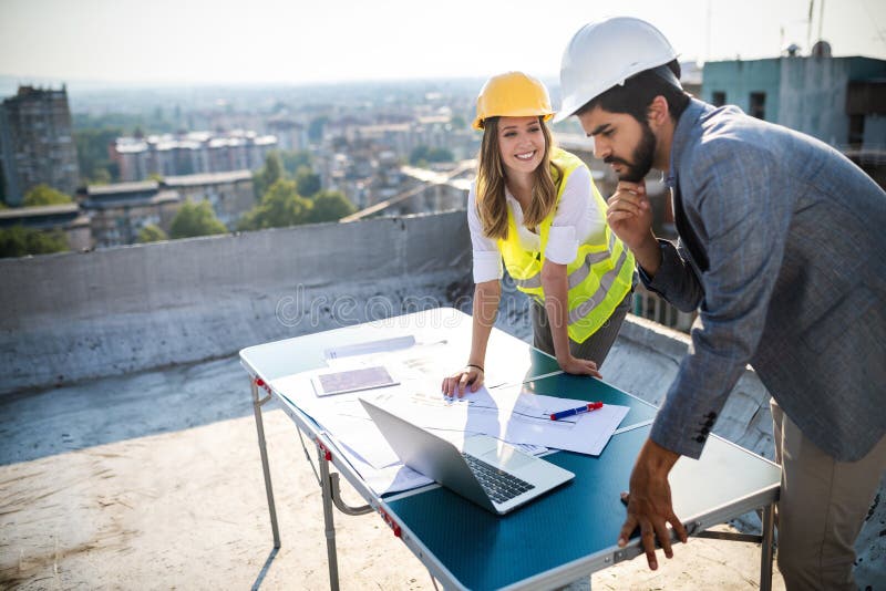 Architects Team and Engineers Looking Paper Plans at Construction Site ...