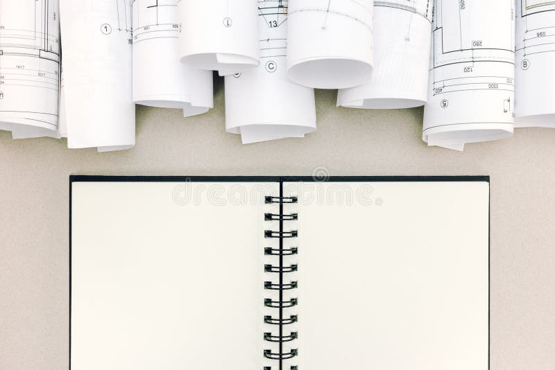 Architectural Blueprint Rolls and and Notepad on Table Stock Photo ...