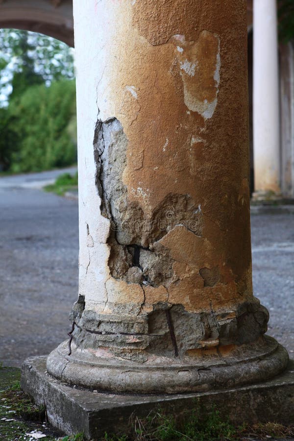An Architectural Column with Deep Cracks and Crumbling Plaster. Traces ...