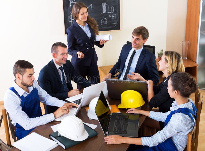 Two Engineers are Discussing an Important Project, Holding a Laptop and ...