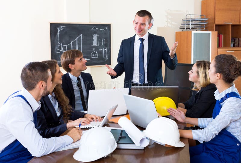 Two Engineers are Discussing an Important Project, Holding a Laptop and ...