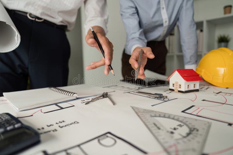 Architectural Planning and Drawing. Close-up of a Team Discussing Blueprints and Designs at a ...
