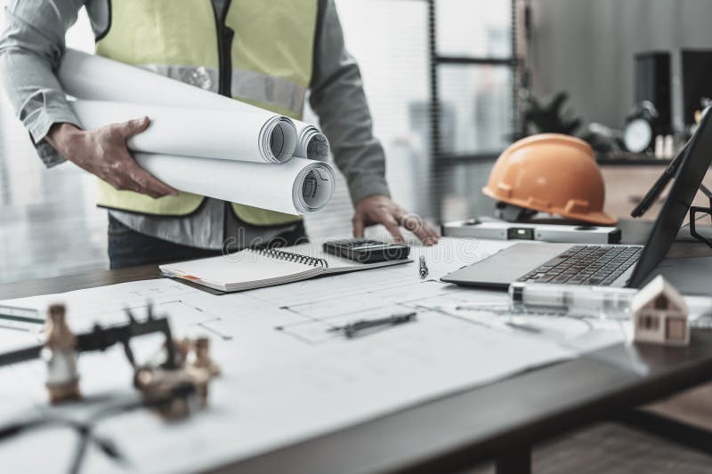 Architect, Engineer Holding Paper Roll Drawings in the Office. Building ...
