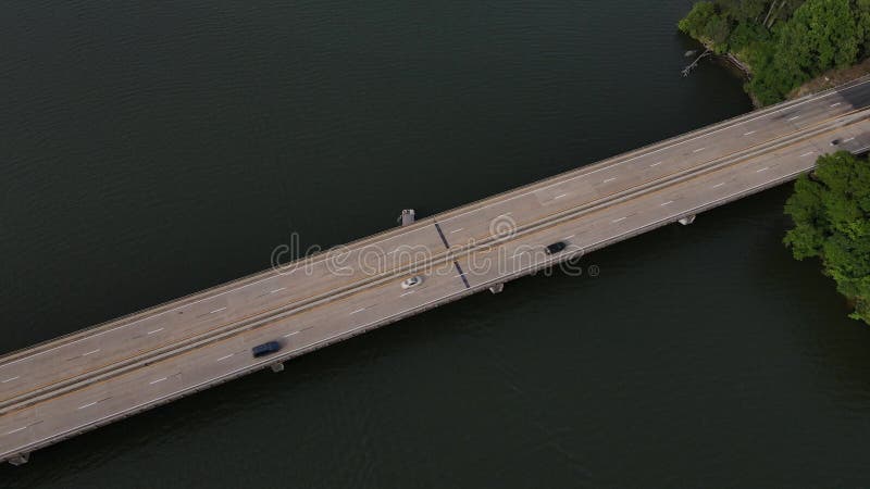 Arial Video of a Bridge on Which Cars Drive and a Black River Under it ...