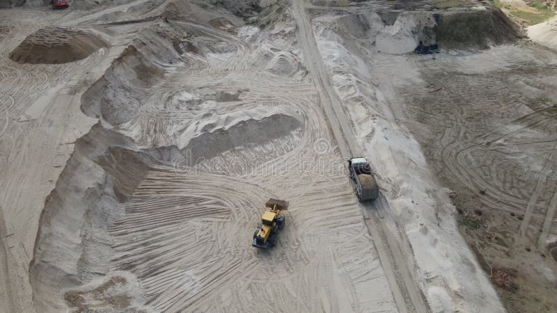 Wheel Loader Loading Sand into Dump Truck in Open Pit Mine. Arial View ...