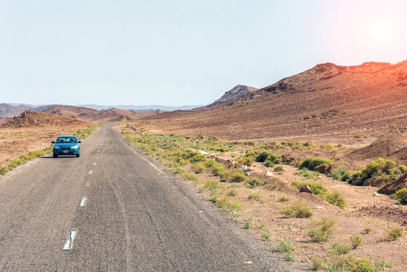 An Arid Hot Desert with Mountains and a Road Under a Blue Sky Stock ...